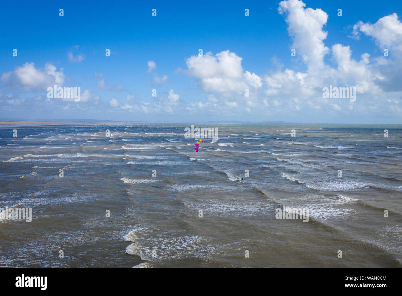 Aerial view of person kite surfing on the water of pendine sands beach ...