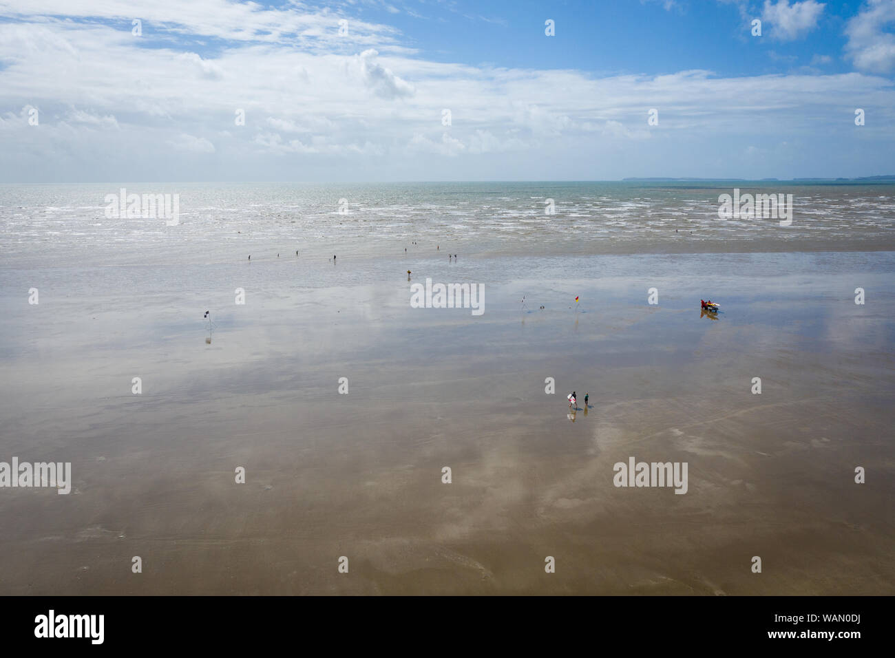 Aerial view of surfers walking to the sea on the beach of Pendine ...