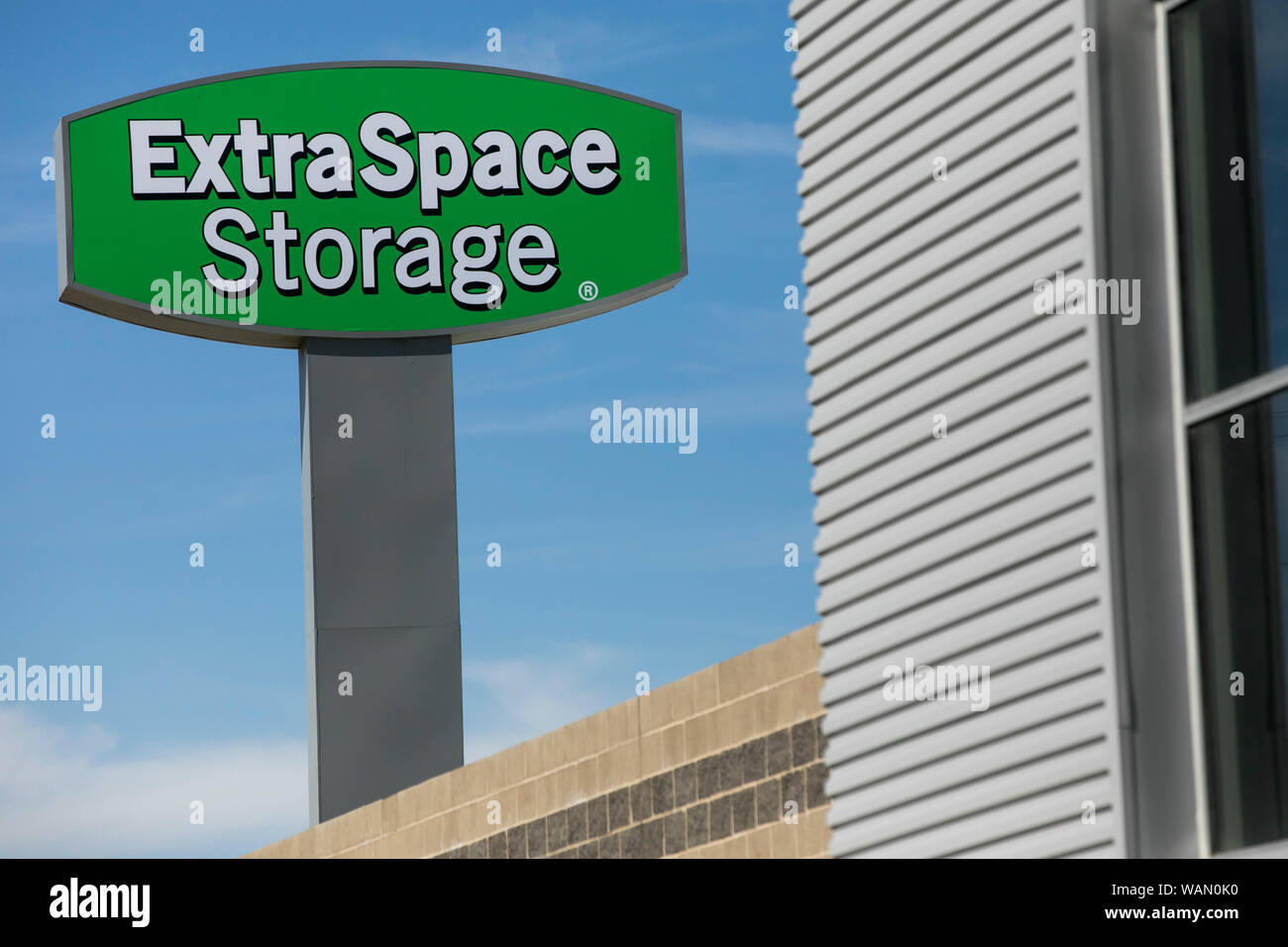 A logo sign outside of a facility occupied by Extra Space Storage in ...