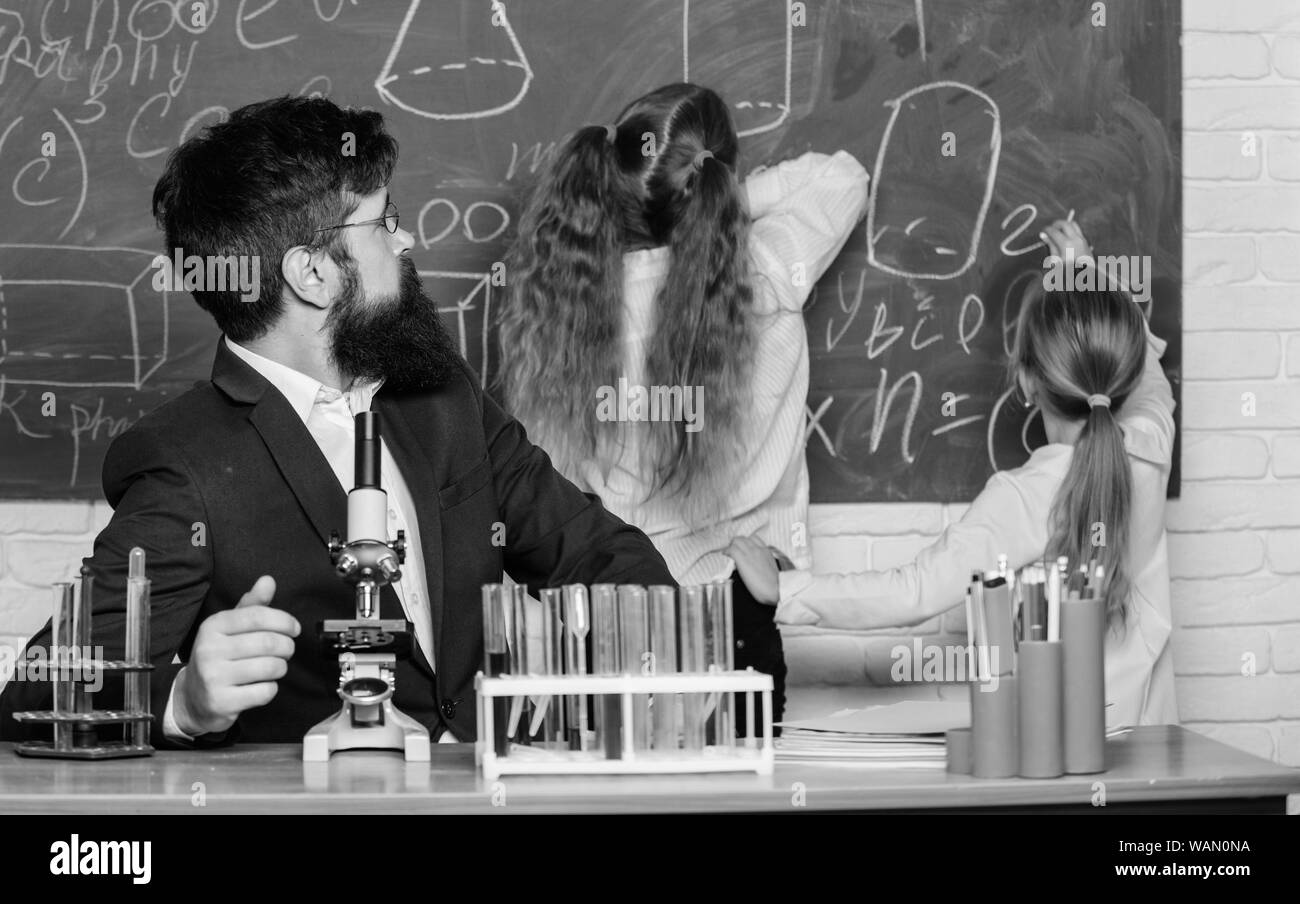 At the lesson. Male teacher giving private lesson to little children ...