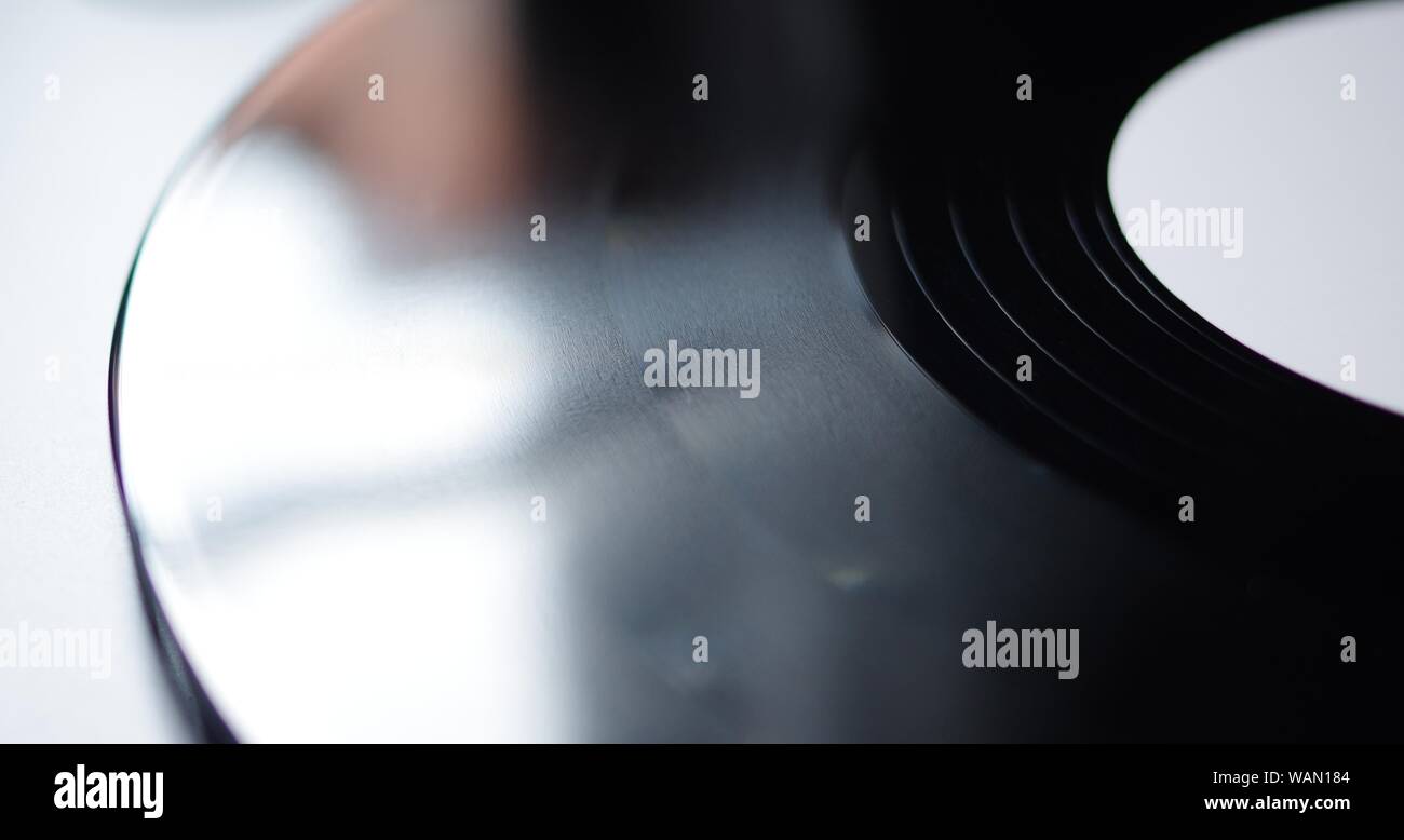 Grooves of tracks on vinyl record disc with white label spinning on ...