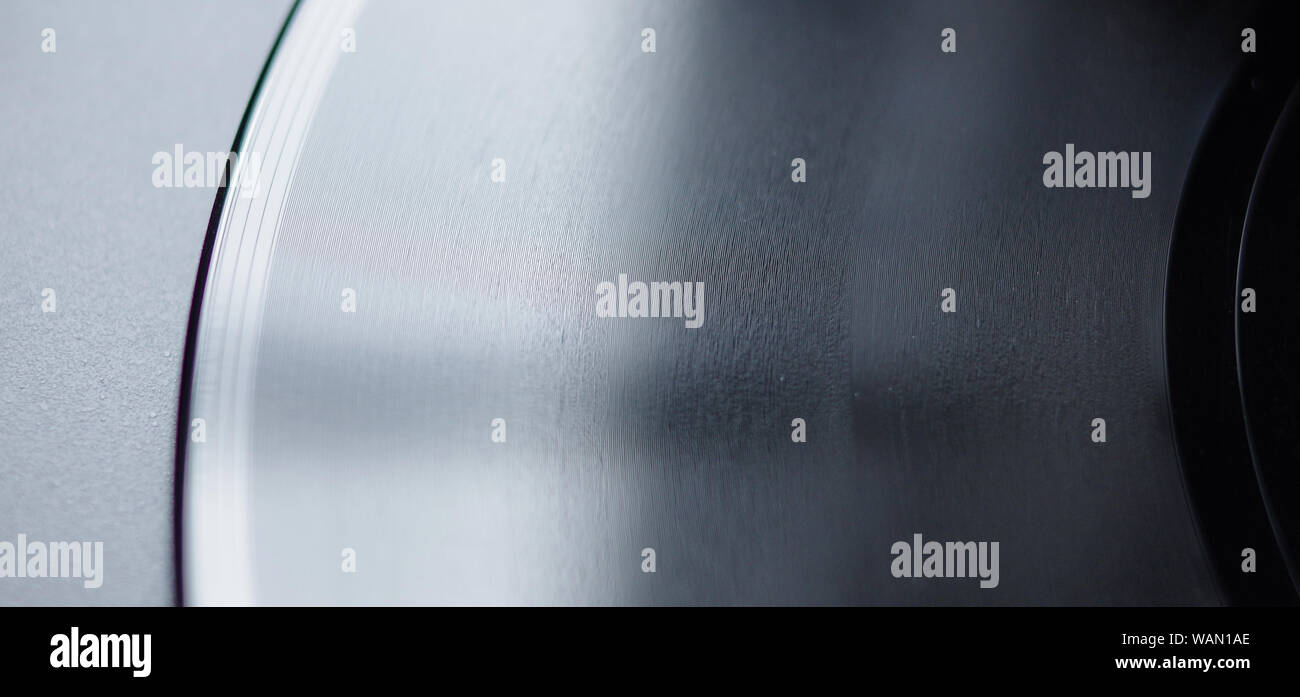 Grooves of tracks on vinyl record disc with white label spinning on ...