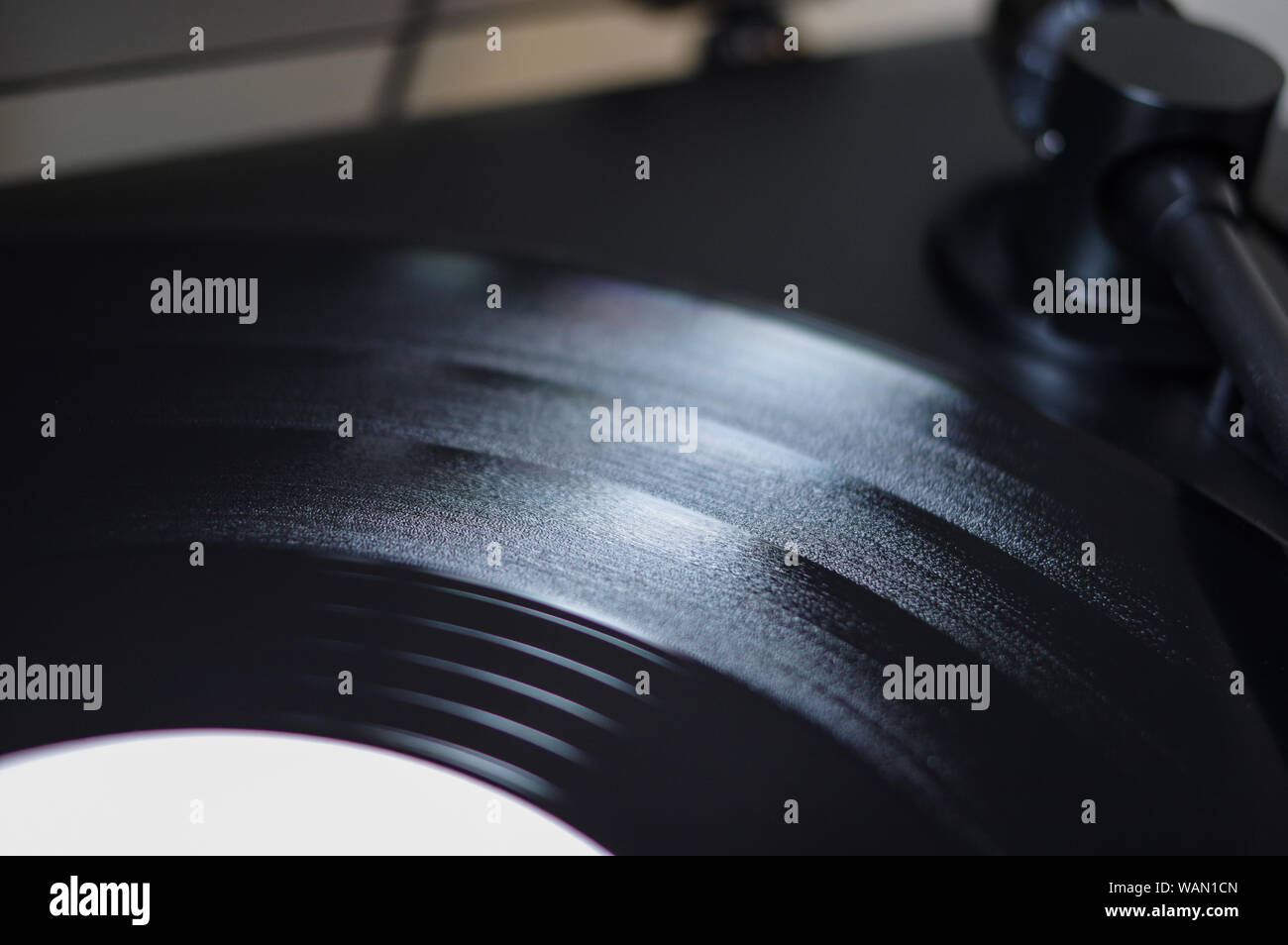 Grooves of tracks on vinyl record disc with white label spinning on ...