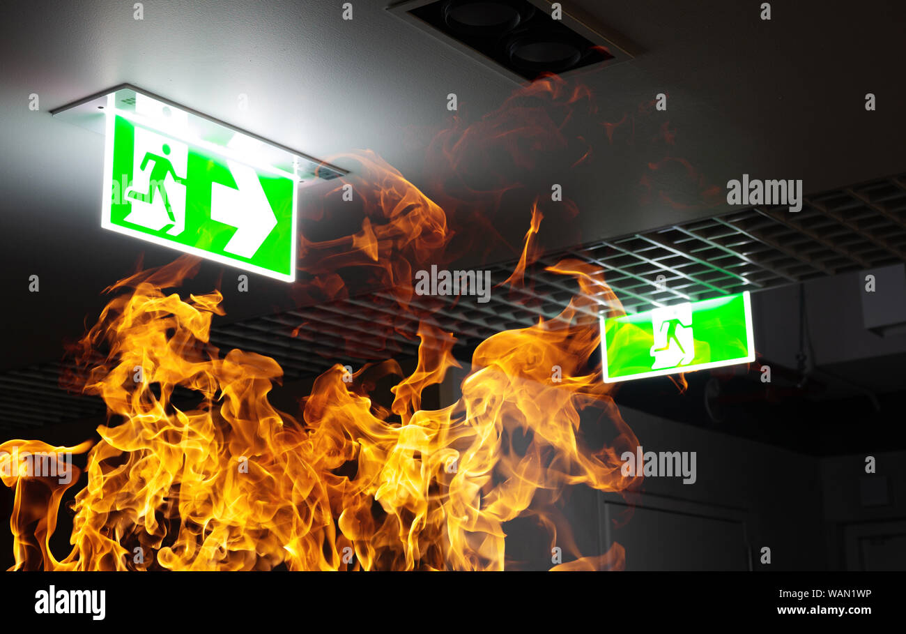 Hot flame fire and green fire escape sign hang on the ceiling in the ...