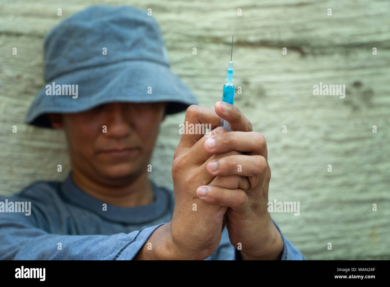 close up of Syringe and Needle in hand of drug addict man. homeless ...