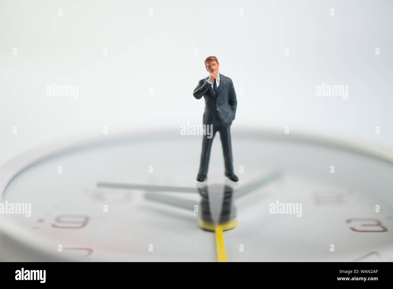 Figure businessmen are thinking And standing on the white watch face by ...