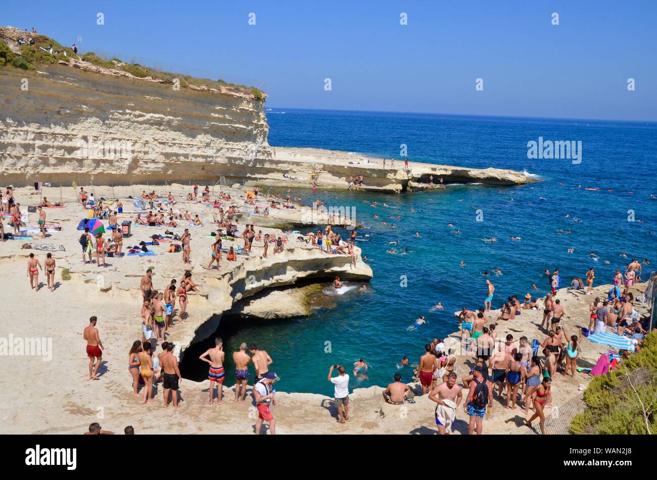 swimmers and divers at st peters pool malta Stock Photo - Alamy