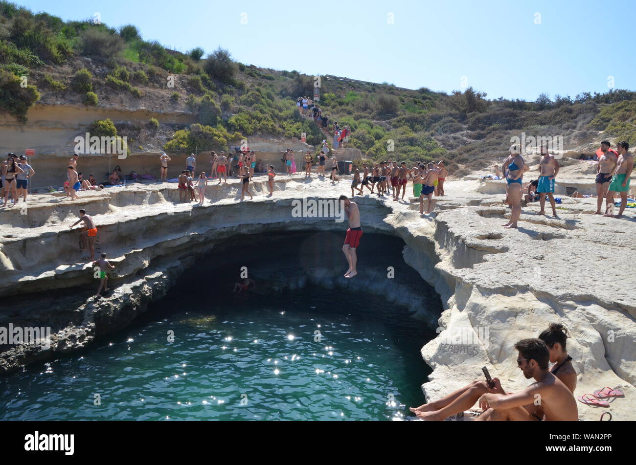 swimmers and divers at st peters pool malta Stock Photo - Alamy