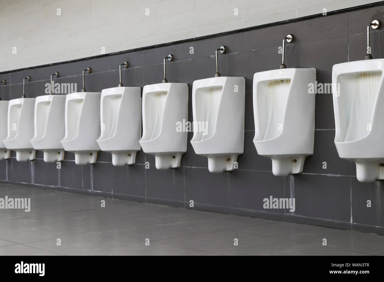 Urinal male installed on the bathroom wall. The white male urinal is ...