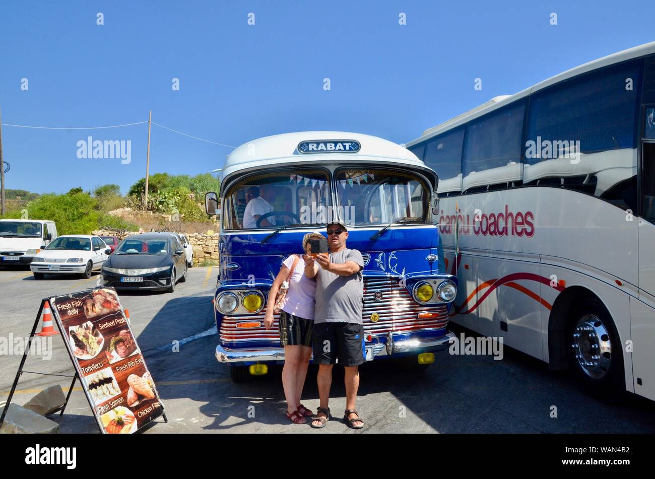 blue grotto malta old and new coach bus side by side Stock Photo - Alamy