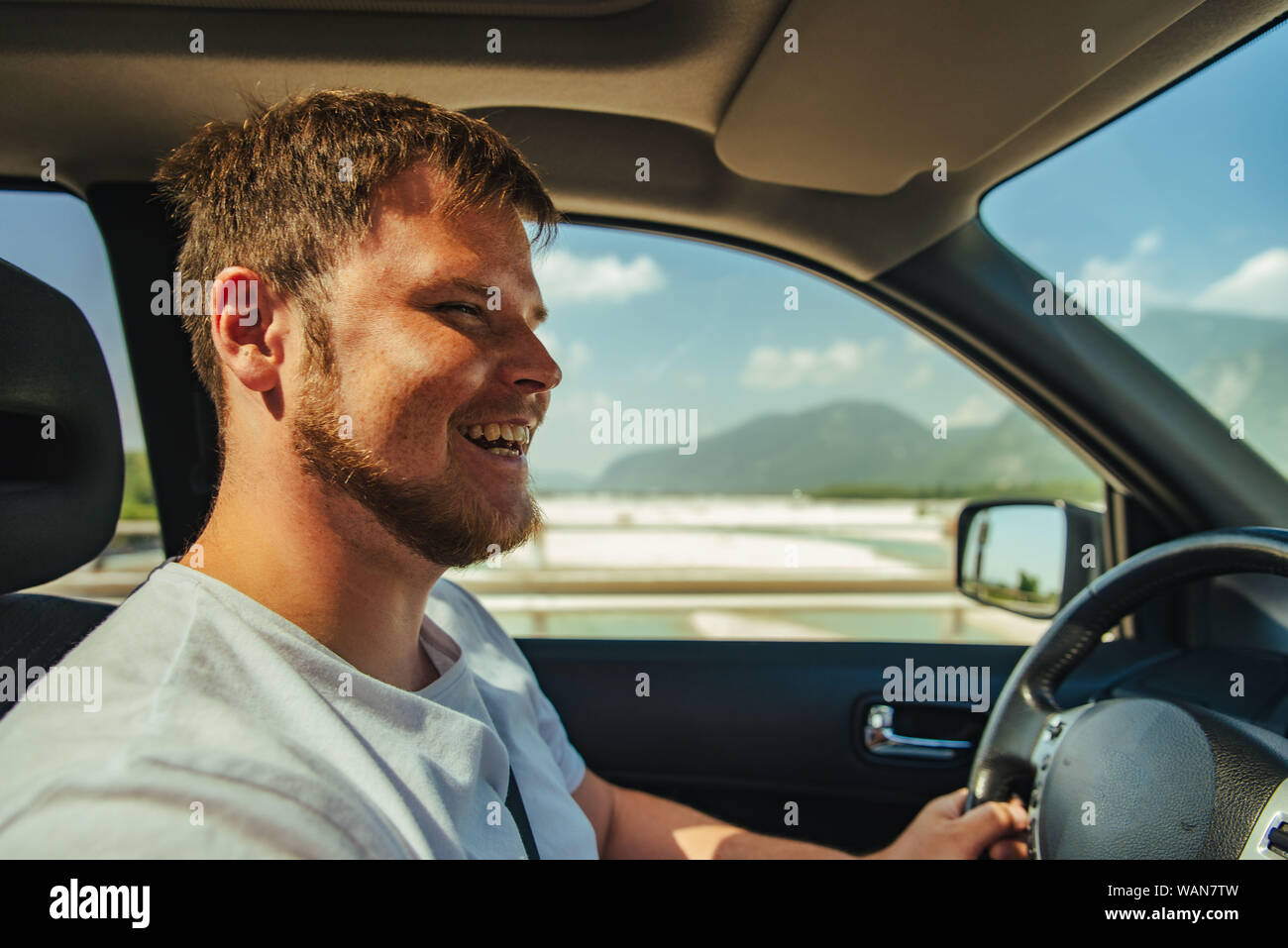 man driving car looking at mountains. road trip Stock Photo - Alamy