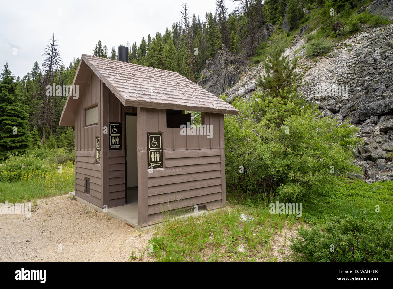 Rustic pit toilet bathrooms outdoors with one stall and handicap access ...