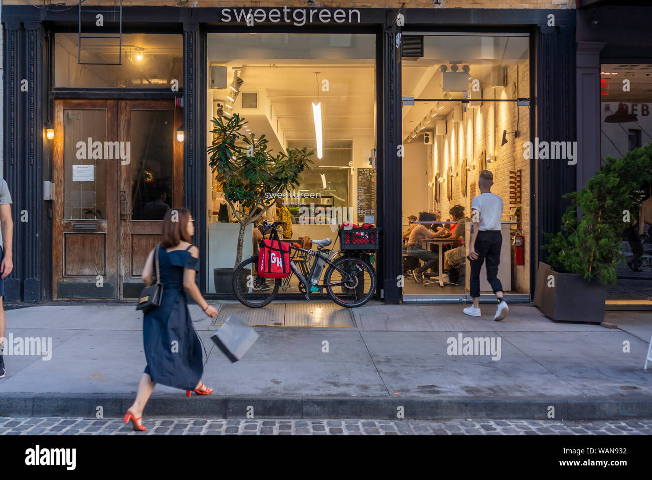 A delivery person's bicycle outside of a Sweetgreen restaurant with ...