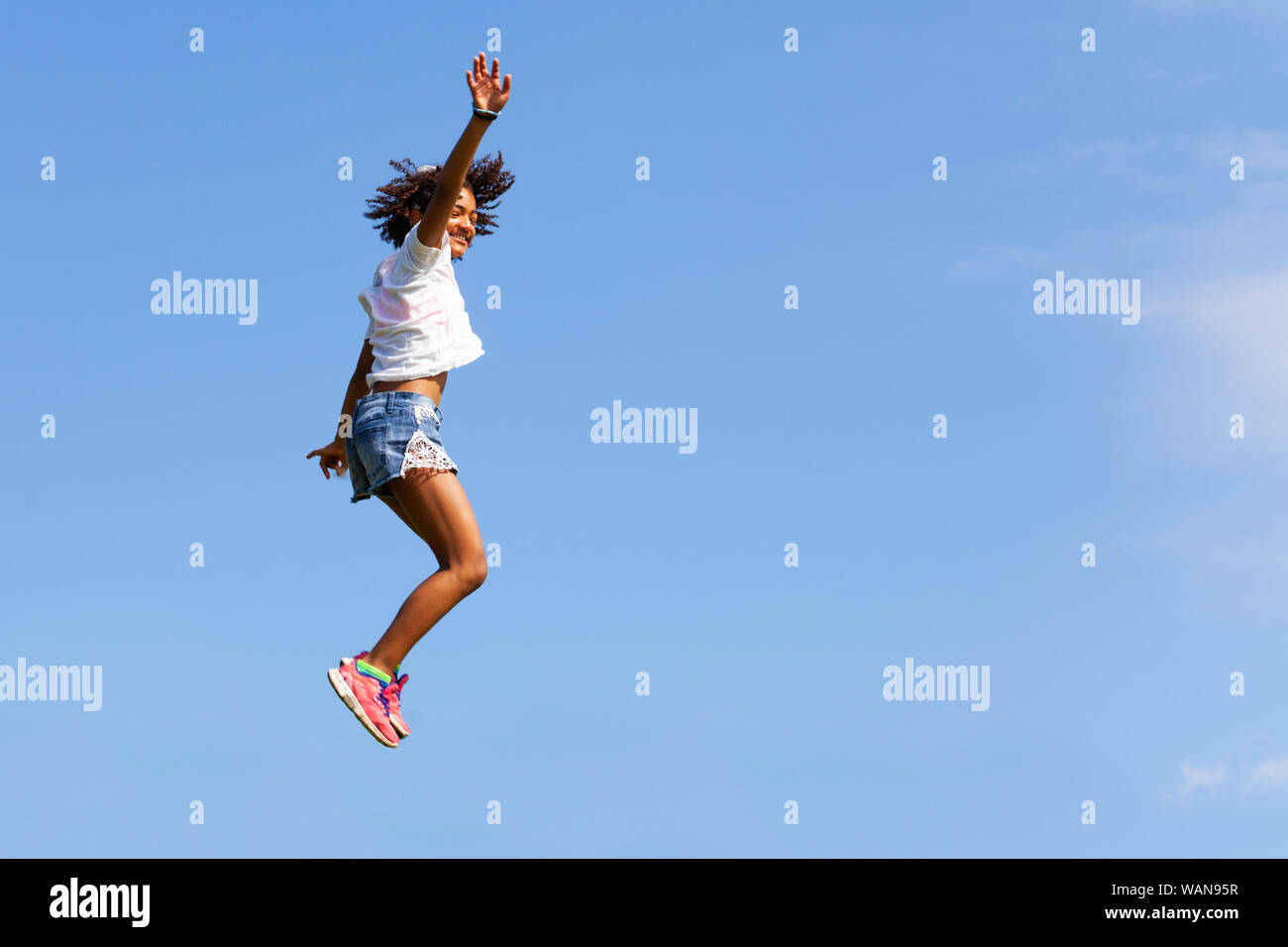 Feel free - cute girl jump with lifted hands Stock Photo - Alamy