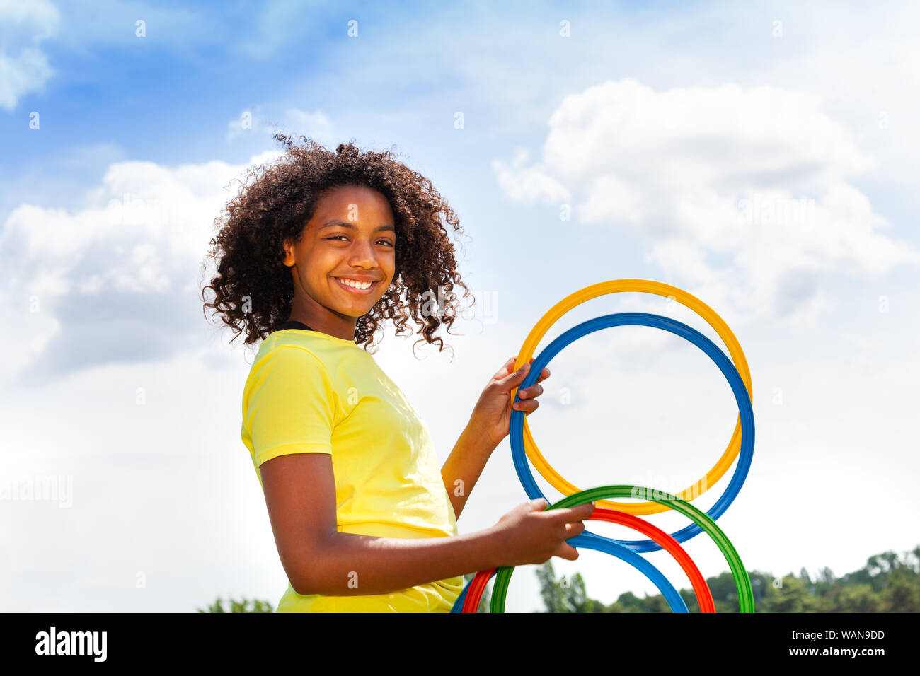 Girl and color hoops rings over sky show big smile Stock Photo - Alamy