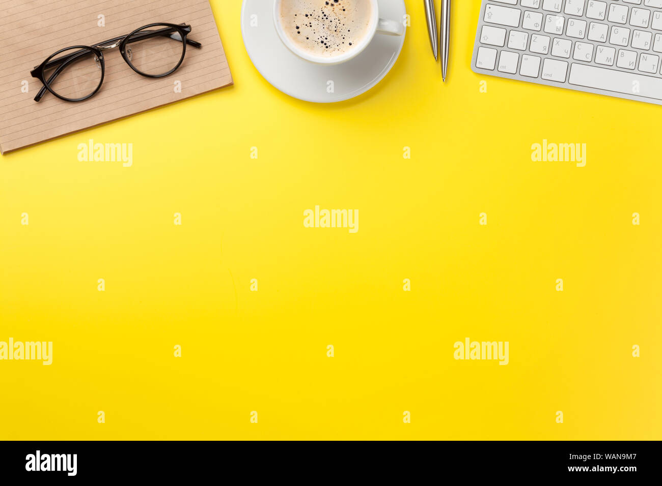 Office yellow workplace backdrop with coffee cup, supplies and computer ...