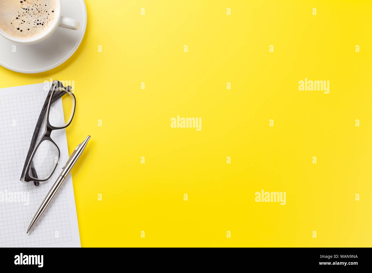 Office yellow workplace backdrop with coffee cup and supplies. Flat lay ...