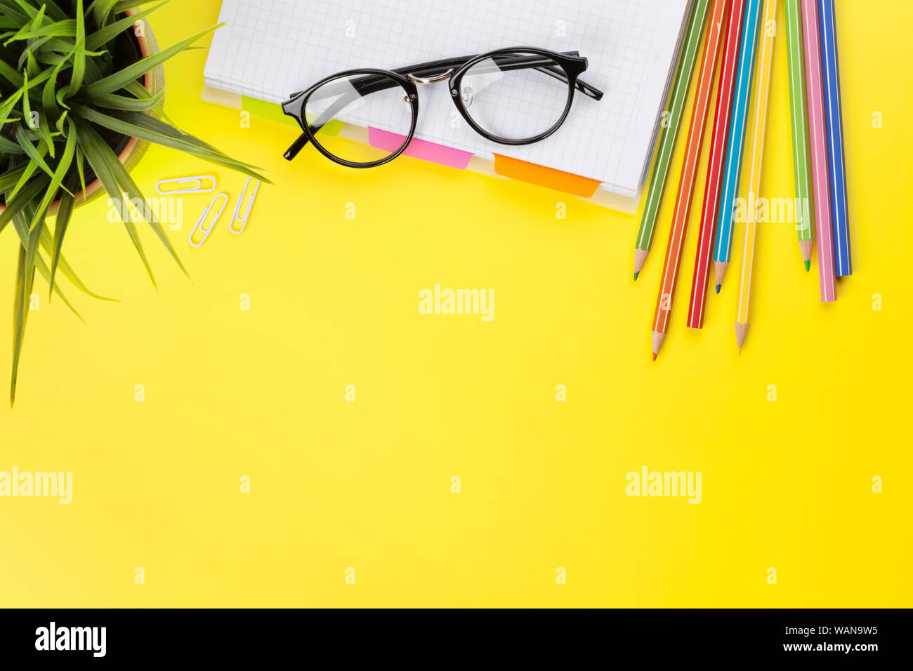 Office yellow workplace backdrop with supplies and glasses. Flat lay ...