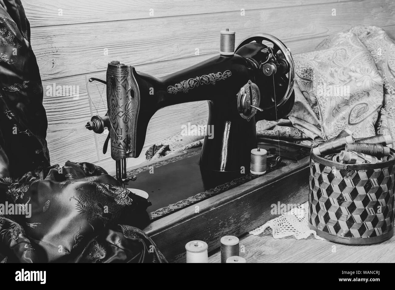 monochrome still life with antique sewing machine, cloth and thread ...