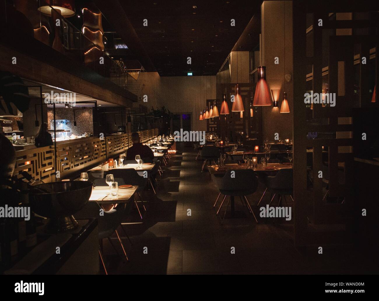 Interior shot of a dark cafe with light brown walls and lights hanging ...