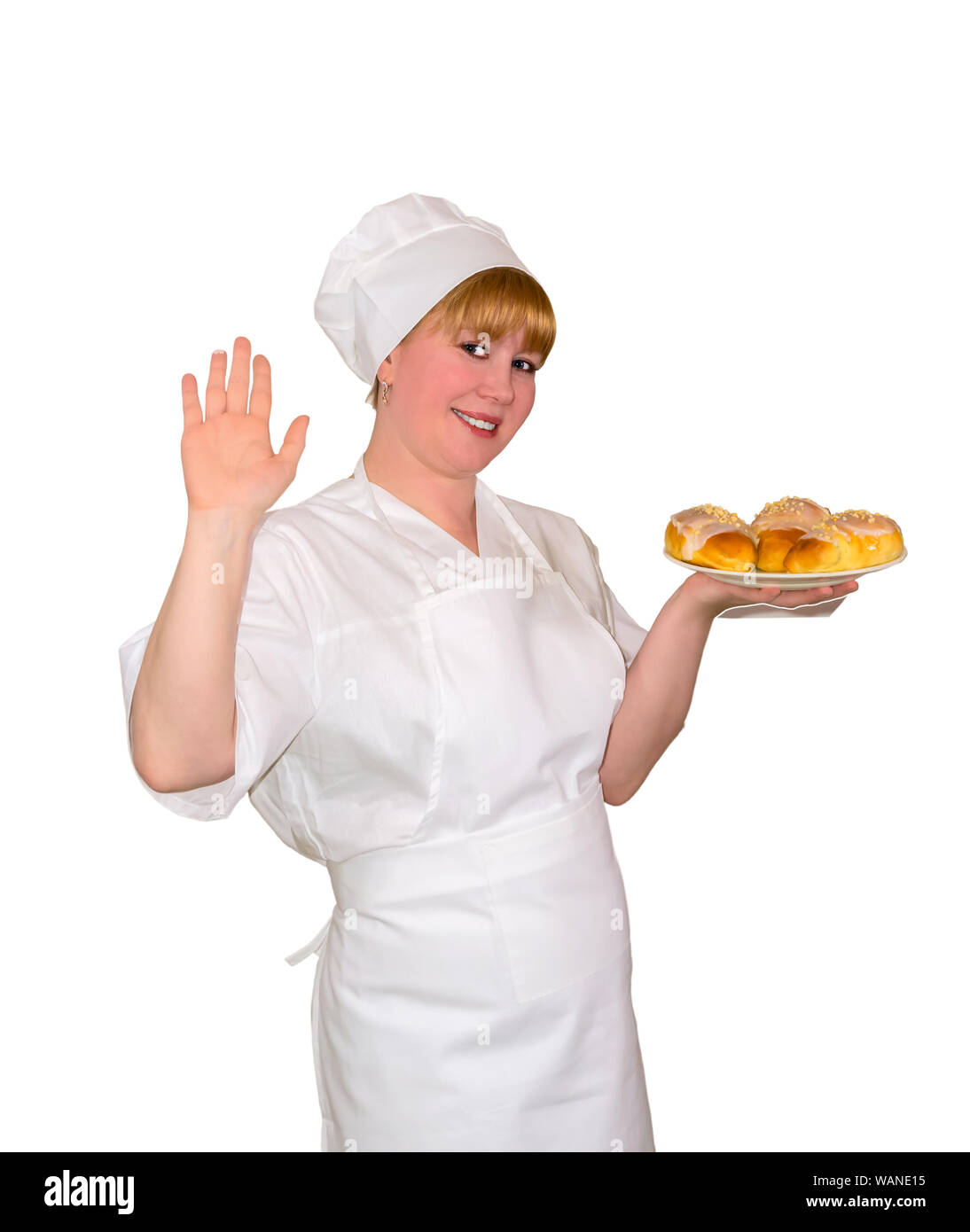 woman baker holds a dish with sweet buns, waves her hand and smiles ...