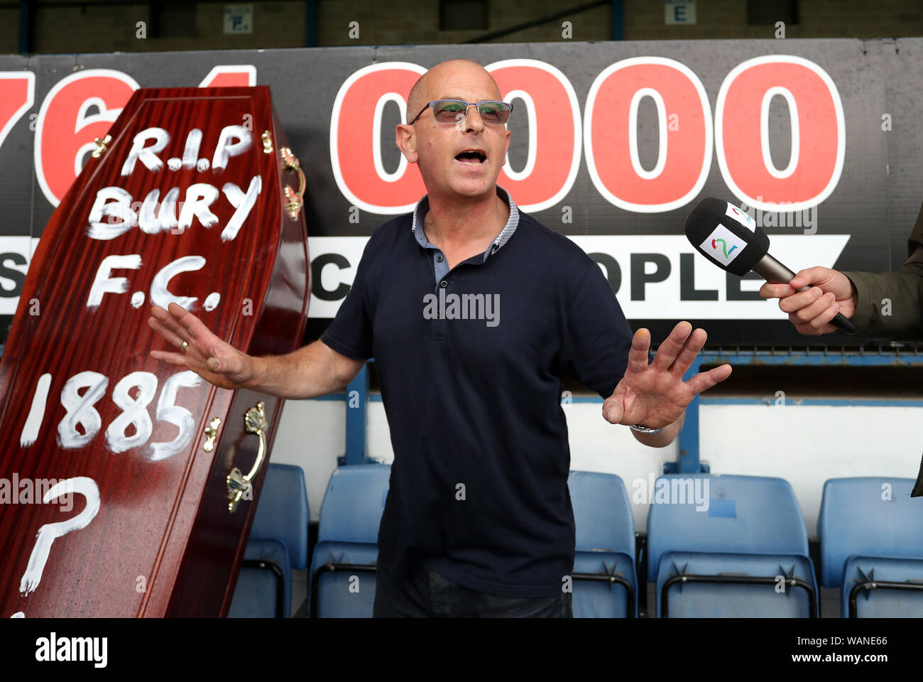 A Bury fan with a coffin is interviewed inside Gigg Lane, Bury Stock ...