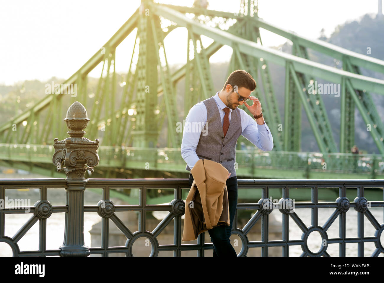 A handsome elegant man standing next to a river on a sunny day Stock ...