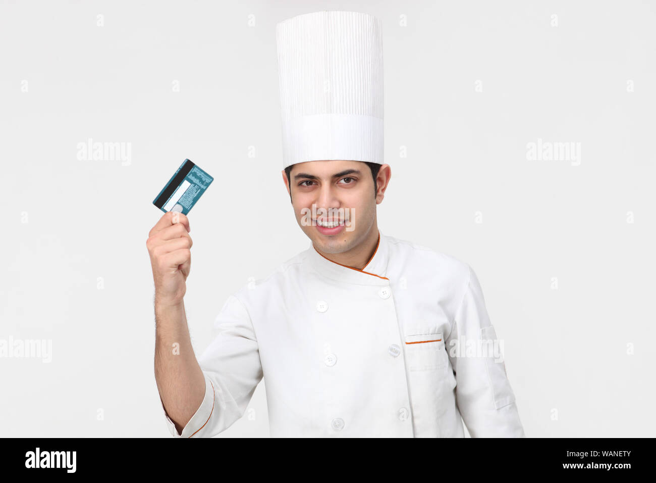 Chef showing credit card and smiling Stock Photo - Alamy