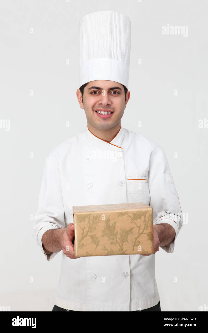 Indian chef holding a gift box and smiling Stock Photo - Alamy