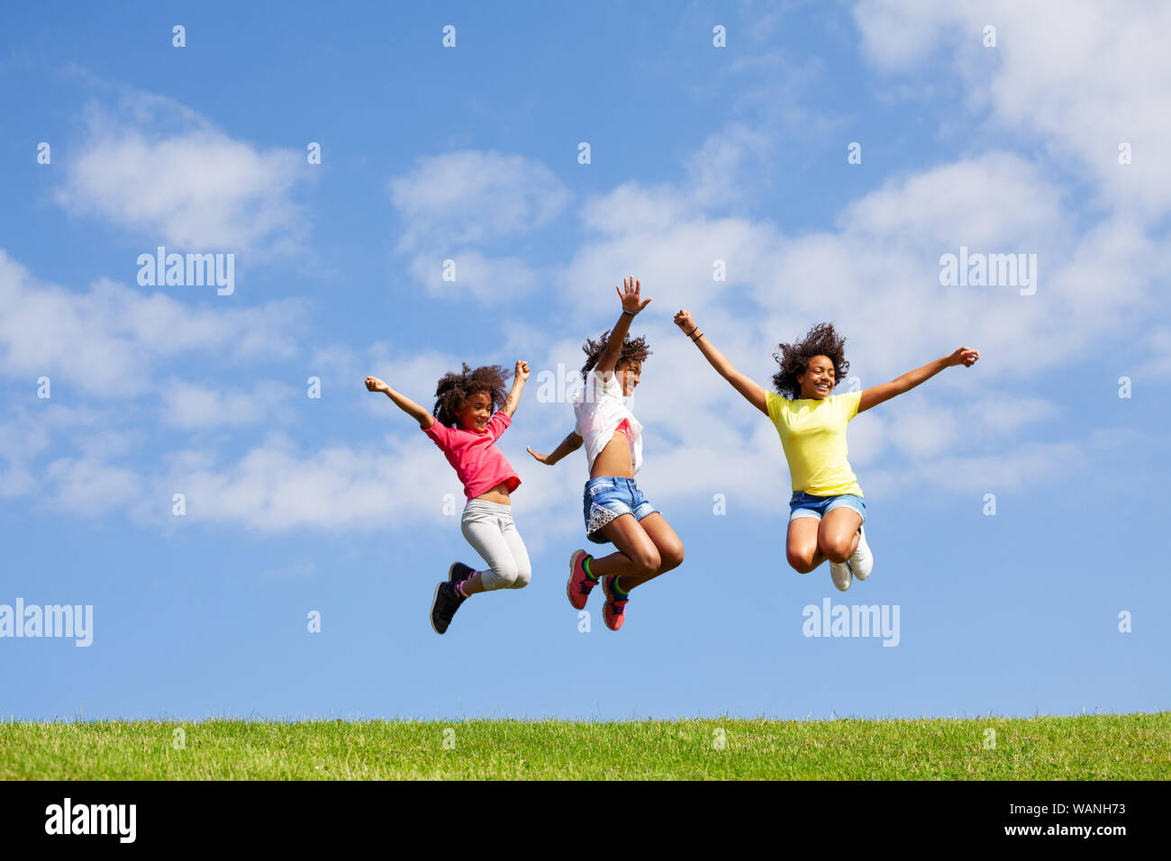 Three cute looking beautiful girls jump over sky Stock Photo - Alamy