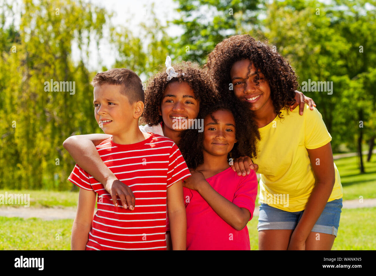 Group of cool diverse kids hug in park together Stock Photo - Alamy