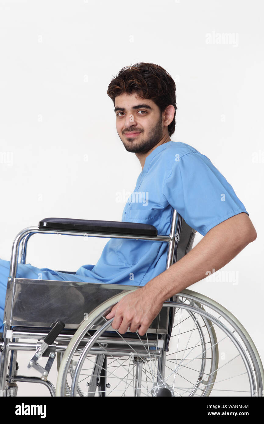 Young man sitting in a wheelchair Stock Photo - Alamy