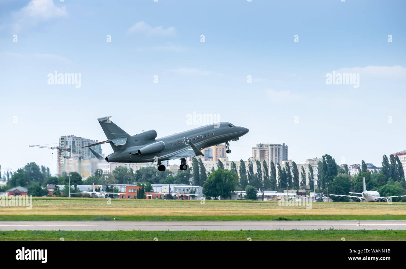 Small private business jet taking off from the city airport Stock Photo ...