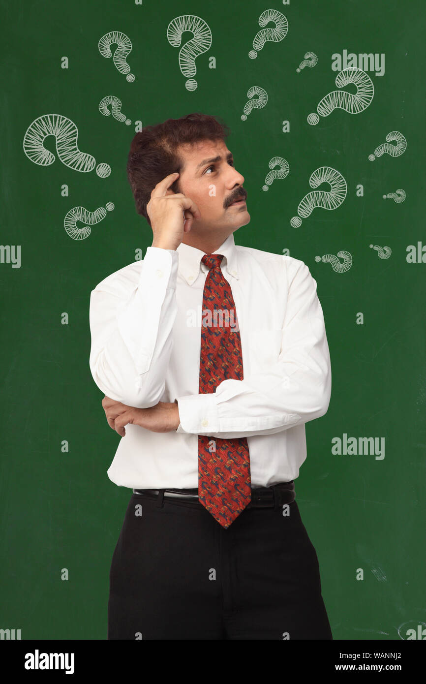Businessman with question marks Stock Photo - Alamy