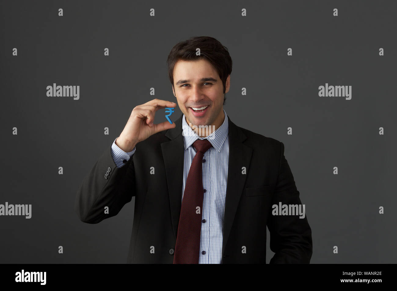 Businessman holding a rupee symbol Stock Photo - Alamy