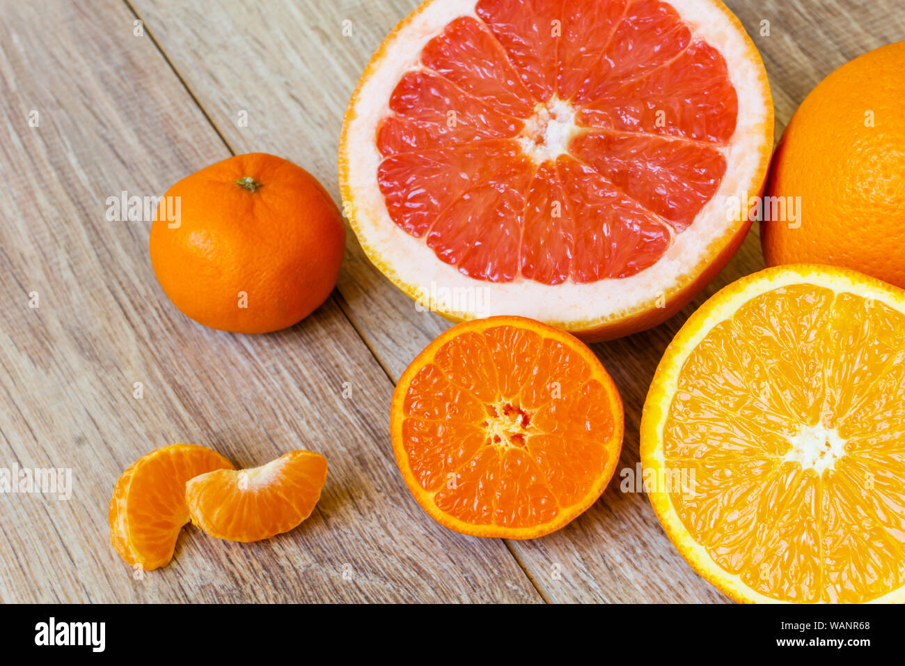 still life - various whole and cut citrus fruits on a light wooden ...