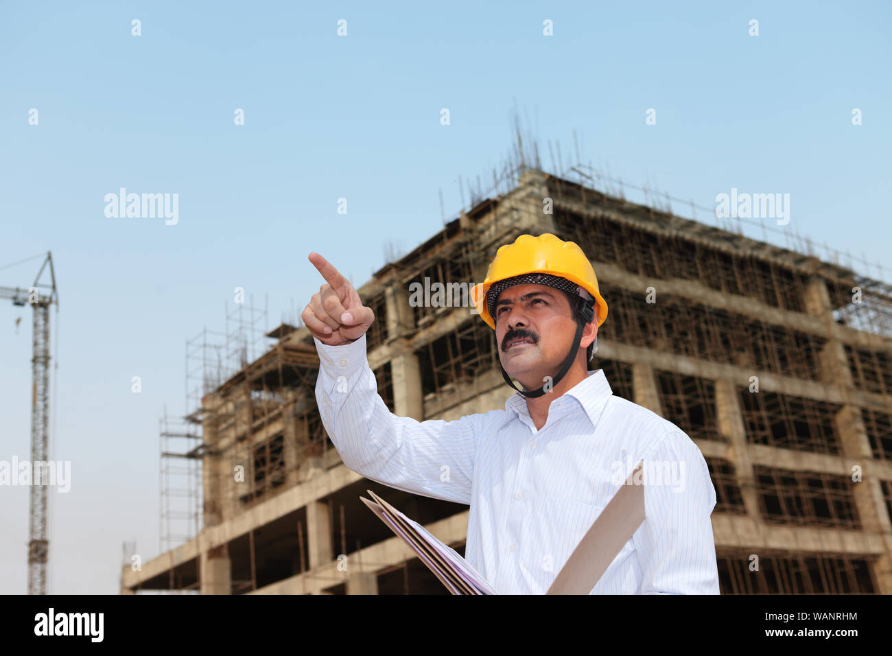 Architect holding paperwork at construction site Stock Photo - Alamy