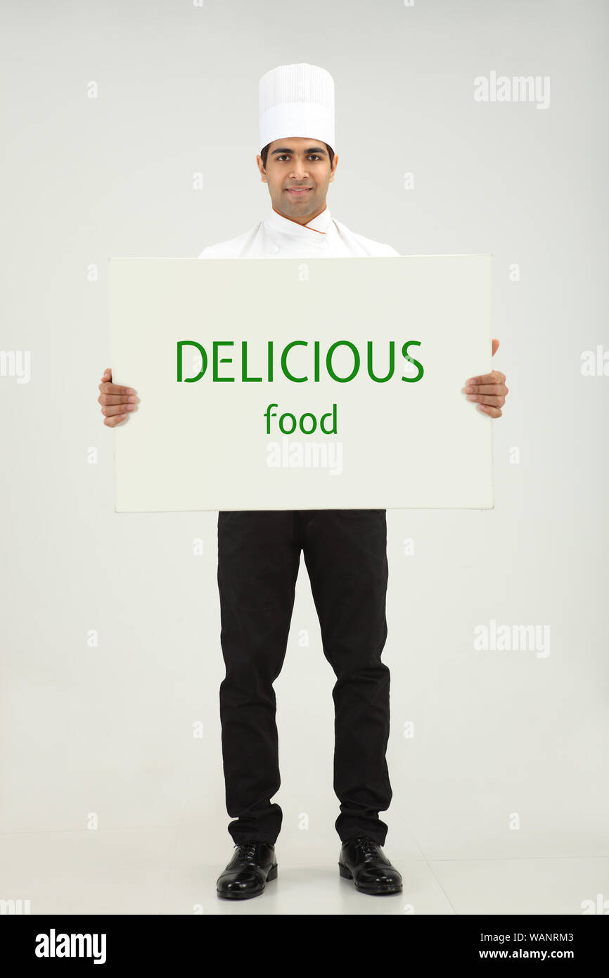 Chef showing placard Delicious food written on it isolated on white ...