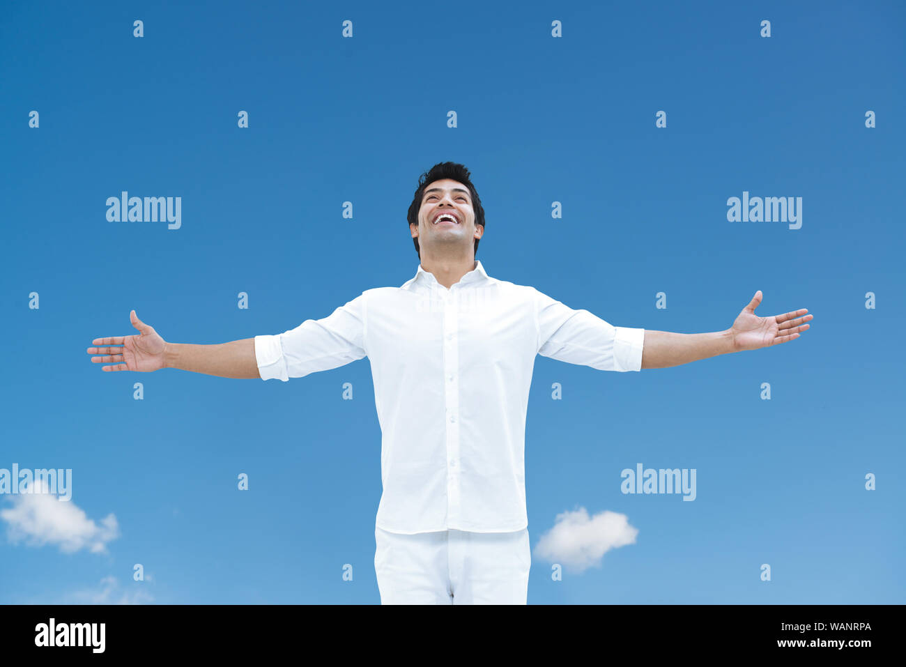 Young man smiling with his arm outstretched Stock Photo - Alamy