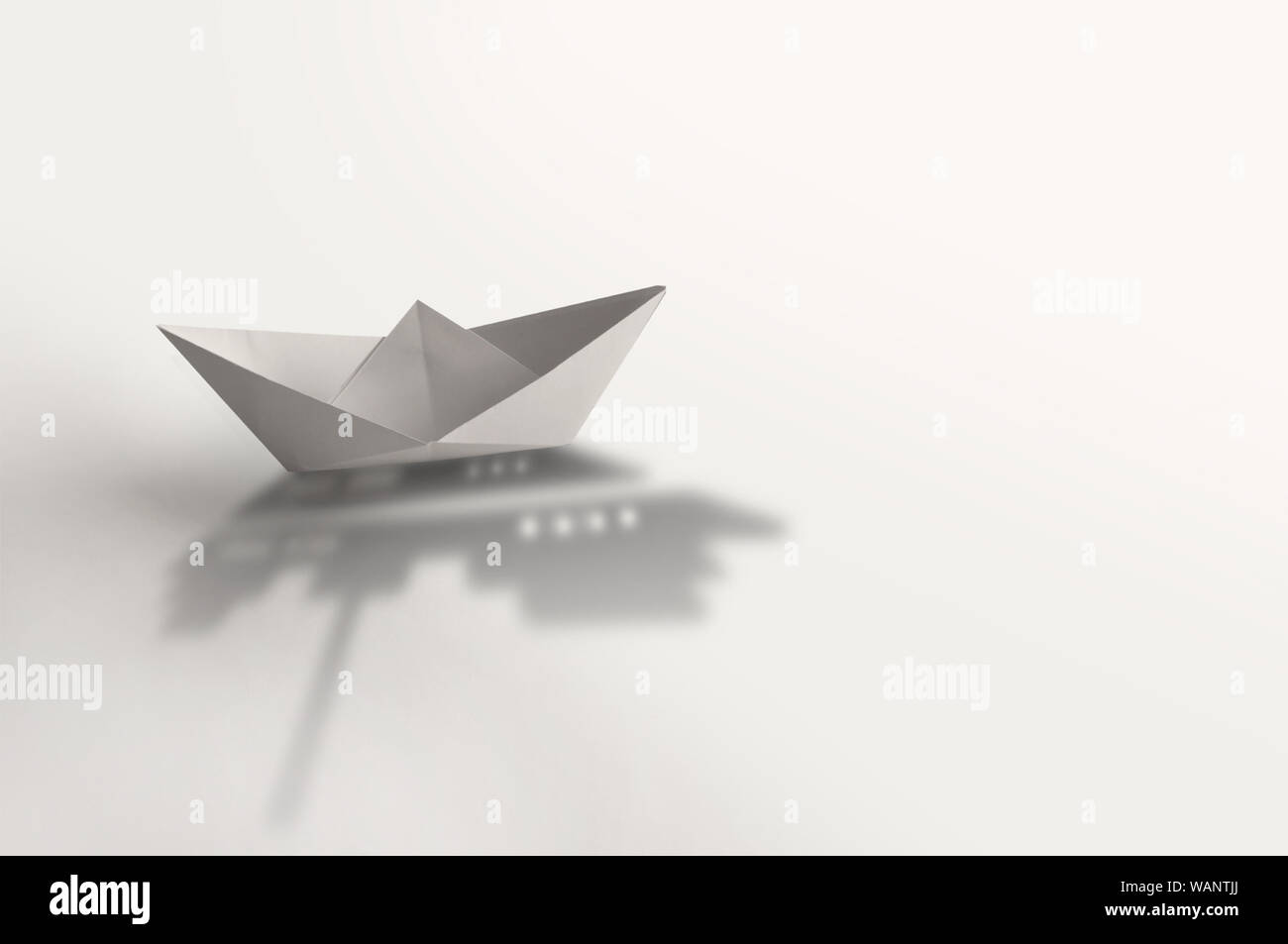 Paper boat with larger shadow of a cruise ship Stock Photo - Alamy
