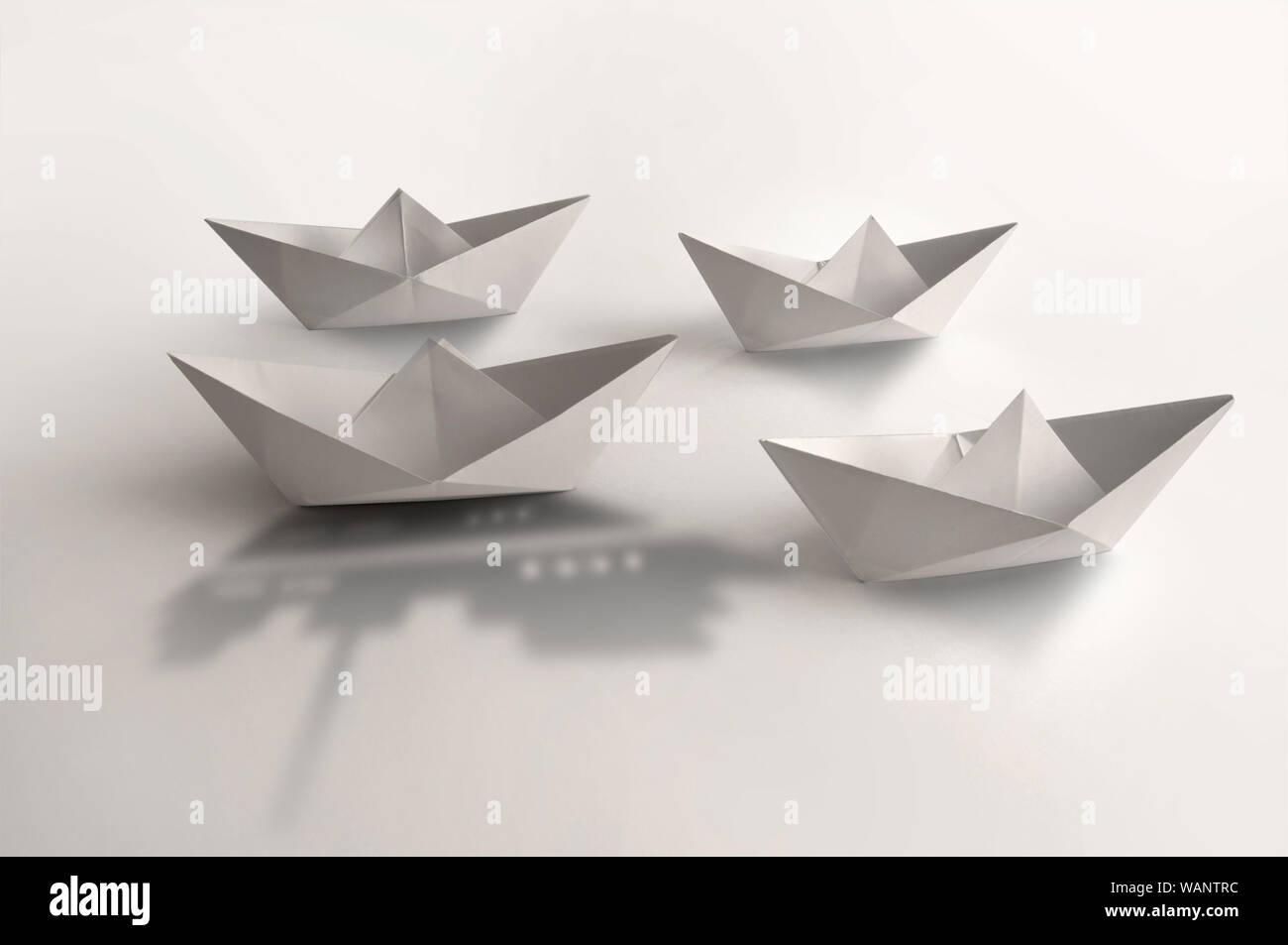 Paper boat with larger shadow of a cruise ship amongst other boats ...