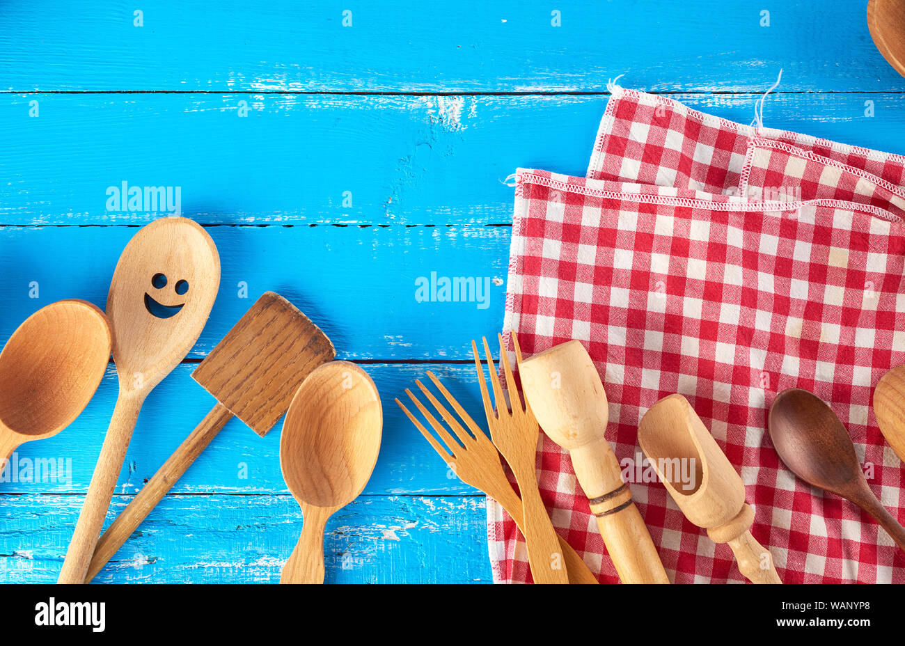 many different wooden spoons, forks on a blue background, copy space ...