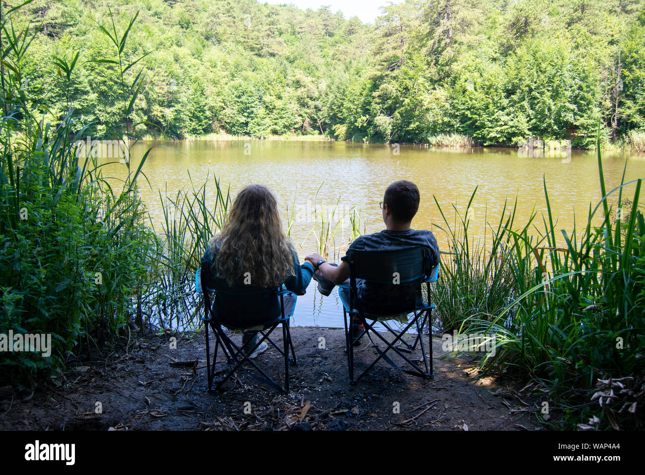 people sitting camping area Stock Photo - Alamy