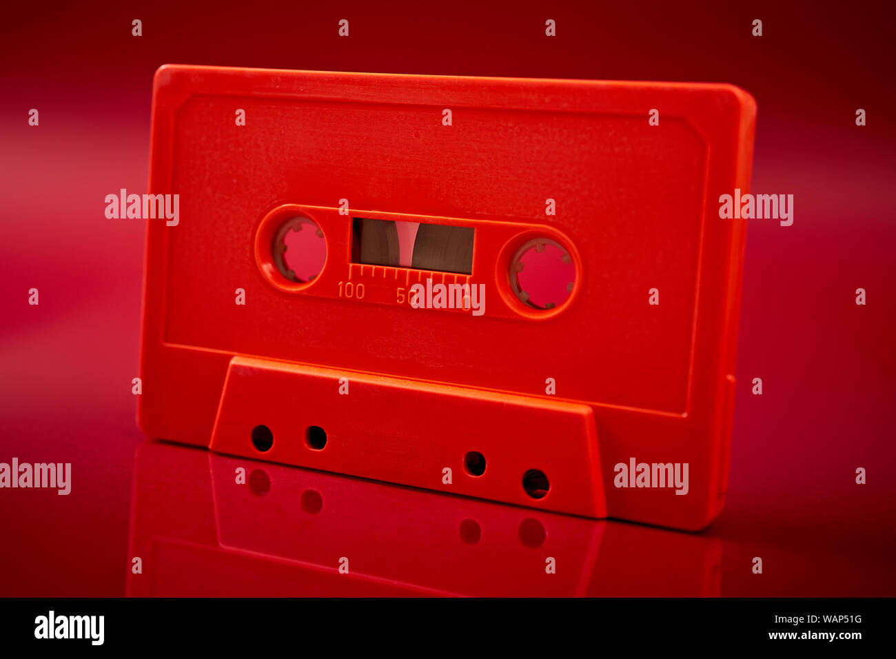 orange audio cassette on the dark red background Stock Photo - Alamy
