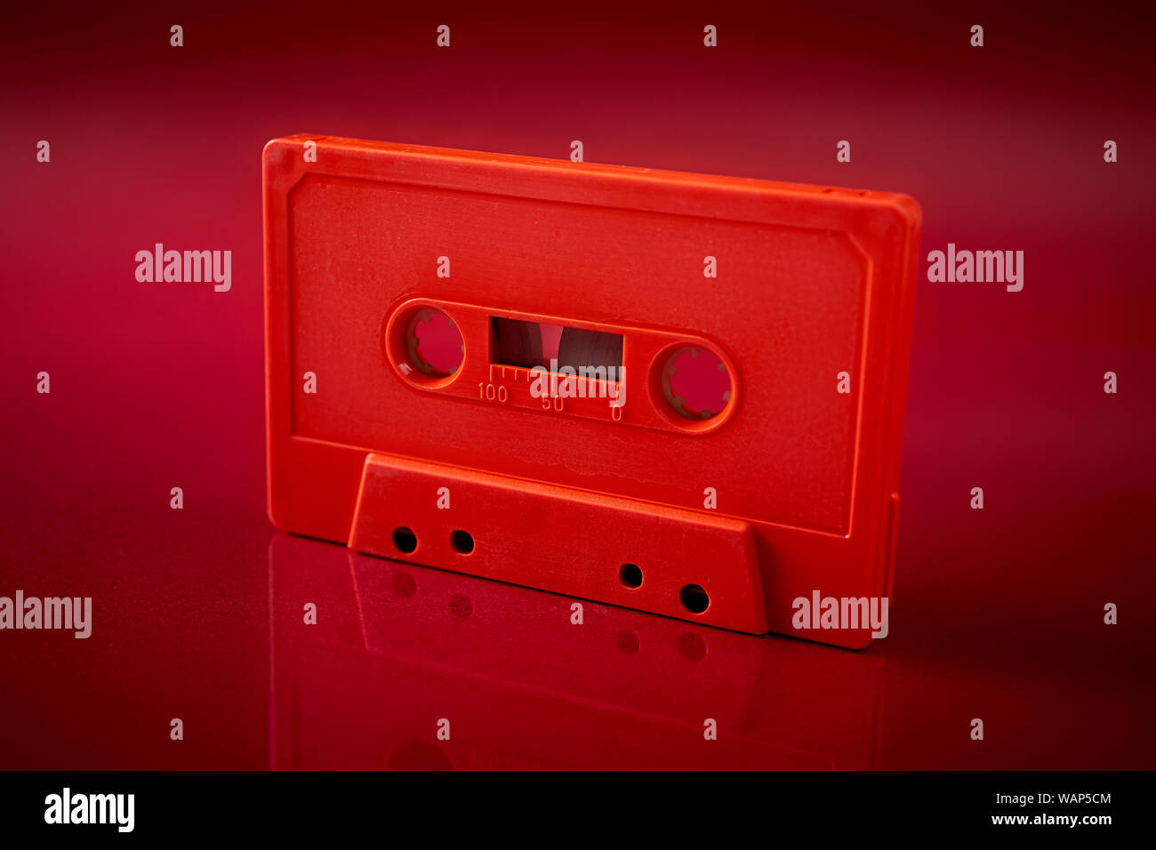 orange audio cassette on the dark red background Stock Photo - Alamy