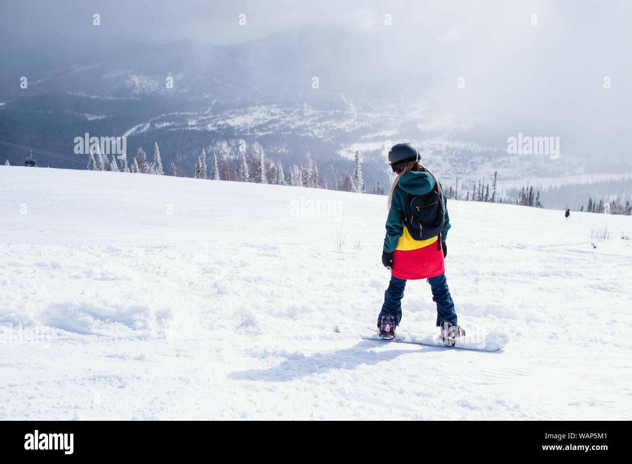 Girl with snowboard in the mountains walking on a snowy slope Stock ...