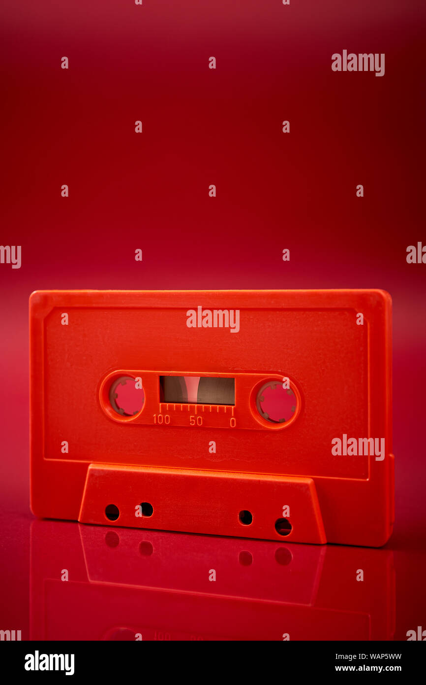 orange audio cassette on the dark red background Stock Photo - Alamy