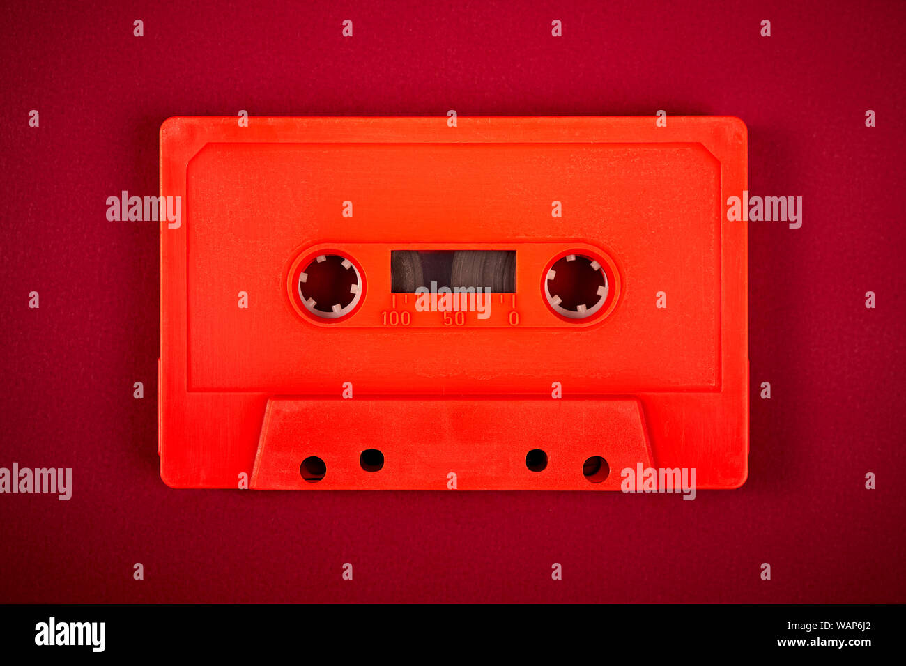 orange audio cassette on the dark red background Stock Photo - Alamy