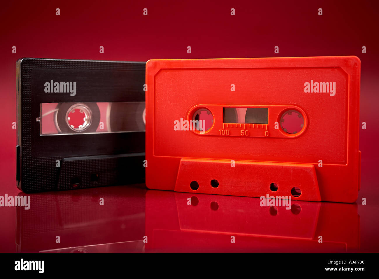 orange and black audio cassette on dark red background Stock Photo - Alamy