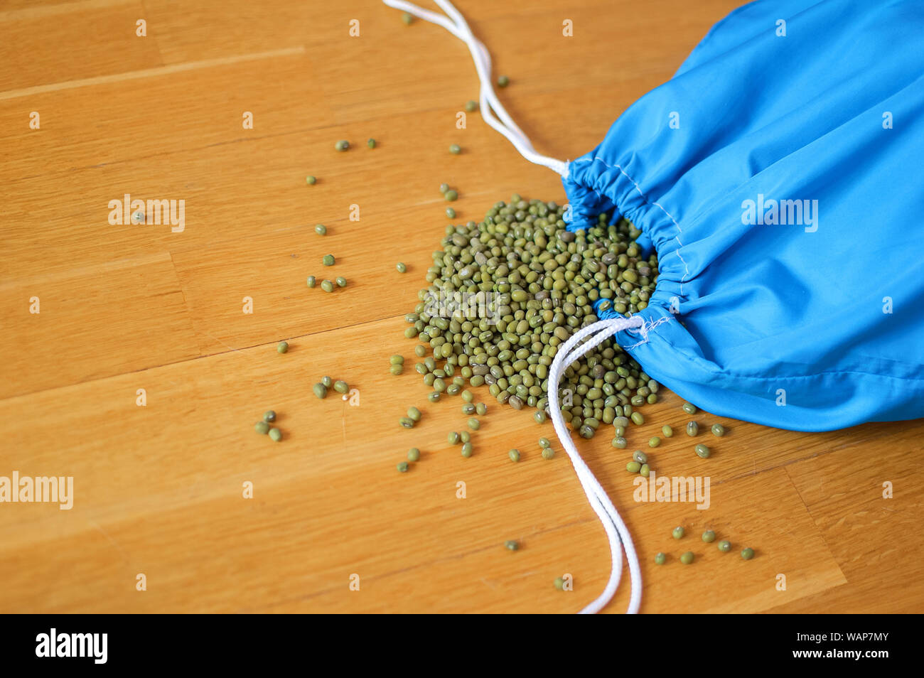 Green mung bean in blue reusable package on wooden background. Eco ...
